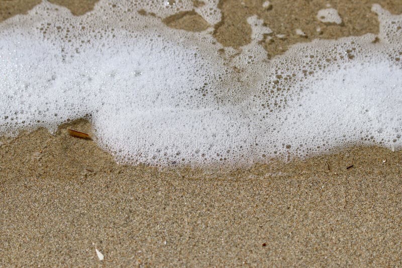 Foamy ocean water on sand stock image. Image of ocean - 136923811