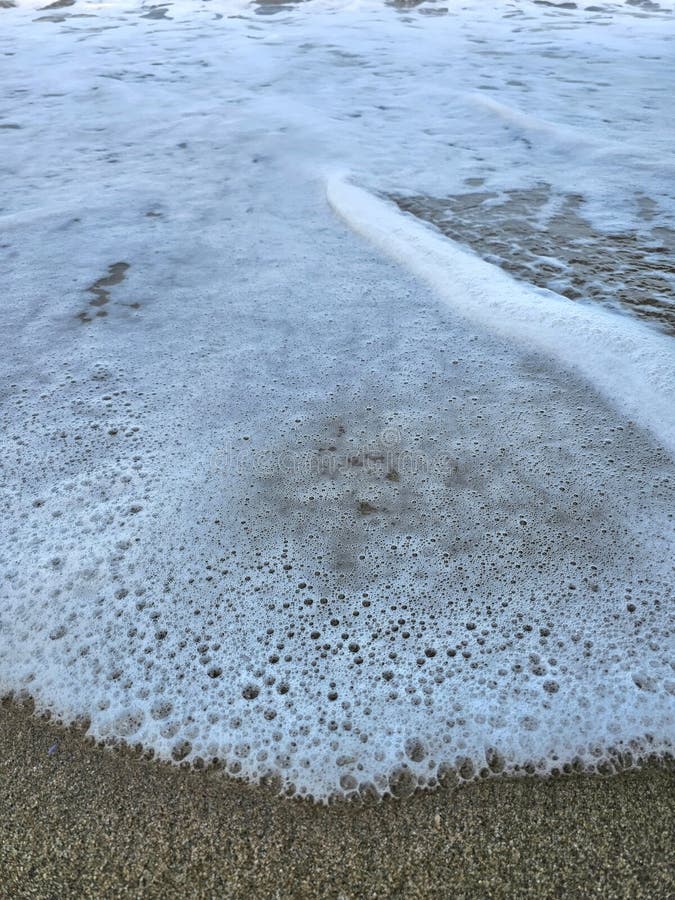Foamy Sea Water Covering the Sand on the Beach Stock Image - Image of ...