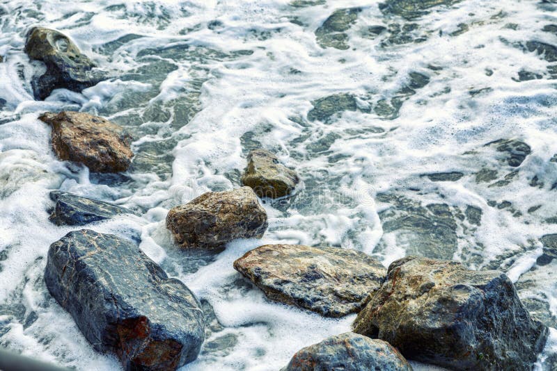 Foamy Sea Waves on Large Rocks on the Shore. Close-up. Background Stock ...
