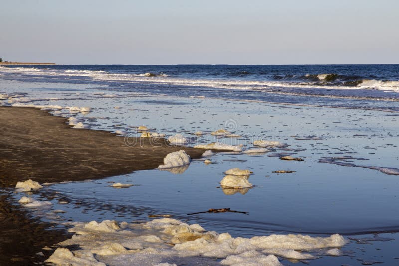 Foamy Shoreline Along a Beach at Sunset with Gentle Waves Lapping the ...