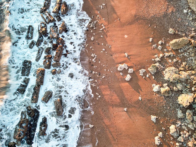 Foamy Tide Splashing on a Sandy Shore with Rocks Stock Photo - Image of ...