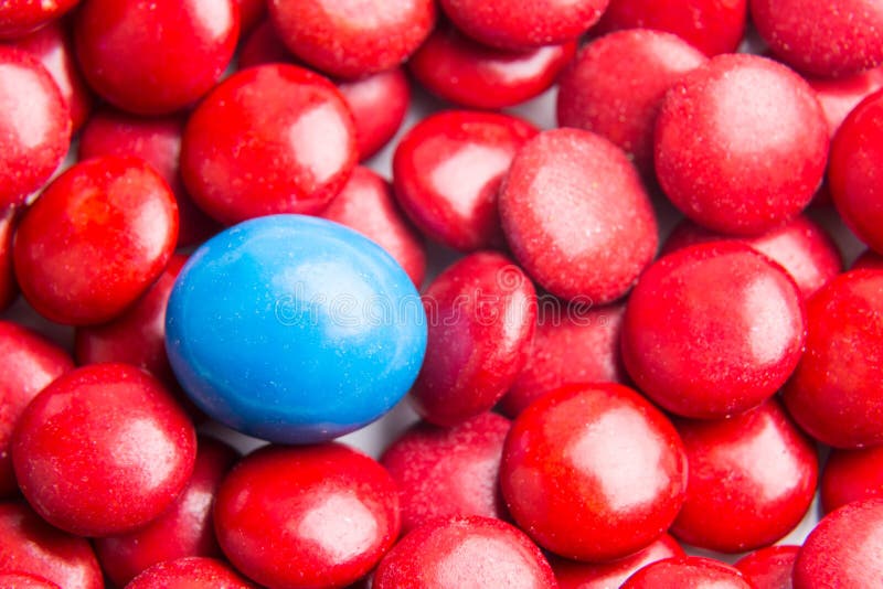 Focus on Blue Chocolate Candy Against Heaps of Red Candies Stock Image ...