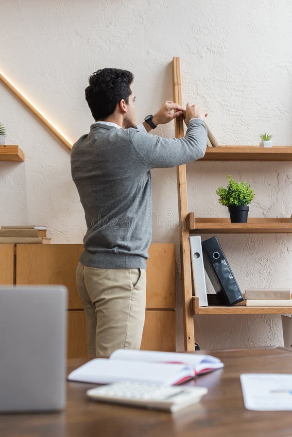 Focus of Businessman Taking Book from Shelves in Office Stock Photo ...