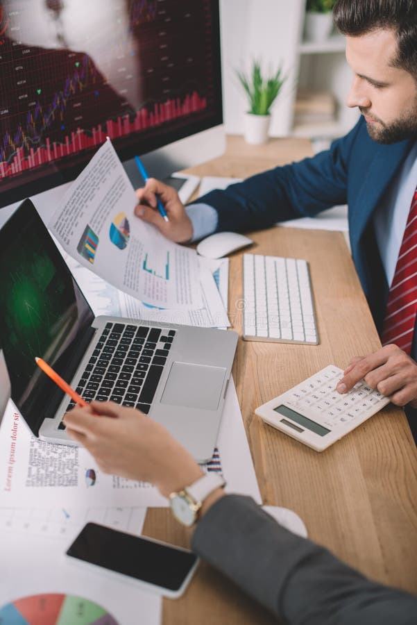 Focus of Data Analyst Working with Charts and Calculator Near Colleague ...