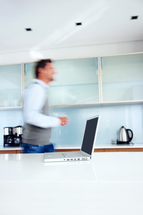 Focus in Laptop - Mature Man Walking in Kitchen. Mature Man Walking in ...