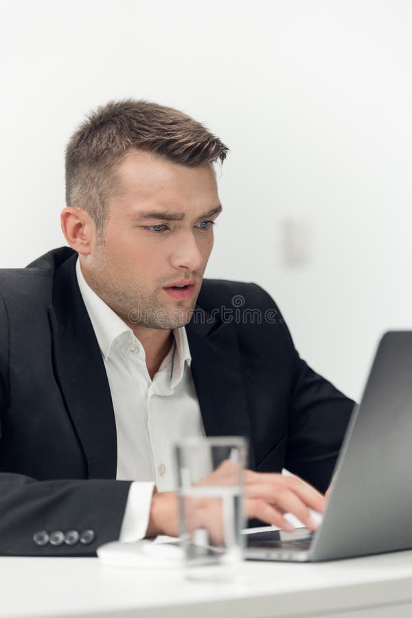 Focus on Man in Suit Sitting at a Table and Typing on a Laptop with ...