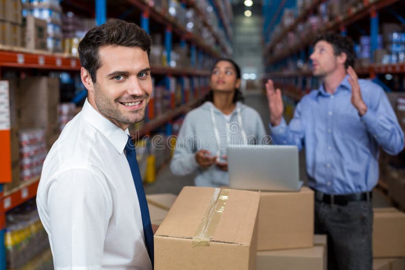 Focus of Manager Holding Cardboard Box and Smiling in Front of Workers ...