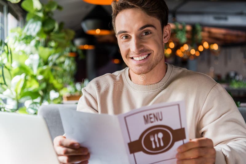 Focus of Positive Man Holding Menu in Restaurant Stock Photo - Image of ...