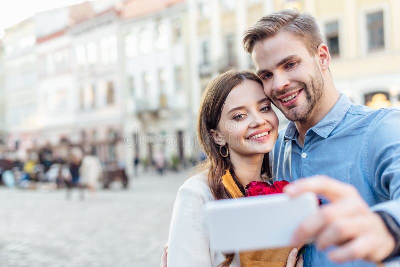 Focus of Smiling Tourists Taking Selfie with Smartphone on Street Stock ...