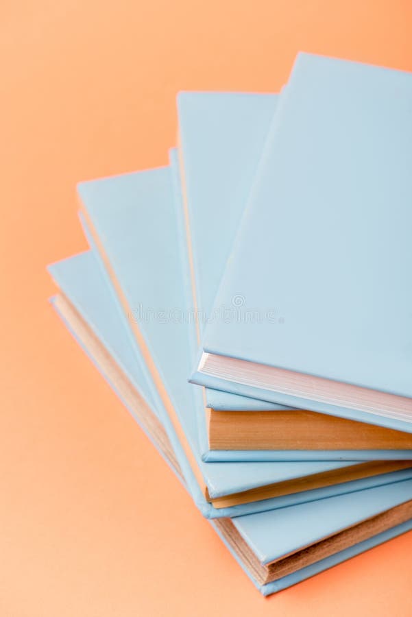 Focus of Stack of Blue Books on Orange Surface Stock Photo - Image of ...