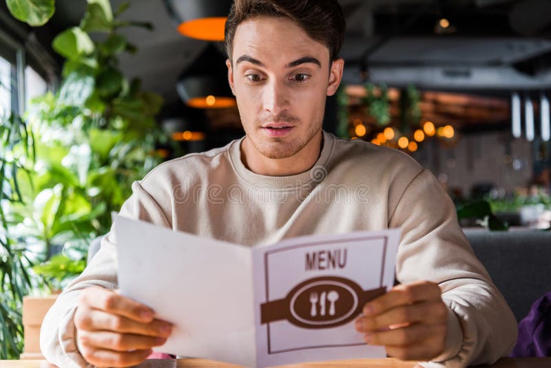 Focus of Surprised Man Holding Menu in Restaurant Stock Photo - Image ...