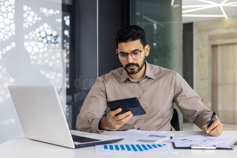 Focused Accountant Working with Documents, Calculator, and Laptop at ...