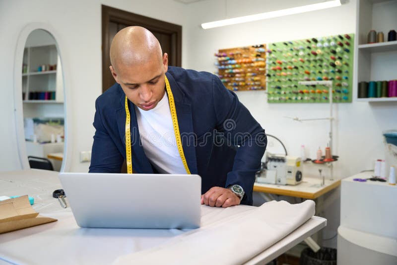 Focused African American Clothier Using His Computer in Workplace Stock ...
