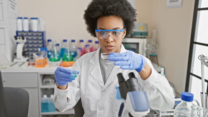 Focused African Woman Scientist Analyzing Samples in a Laboratory ...