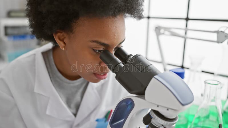 Focused African Woman Scientist Using Microscope in Modern Laboratory ...