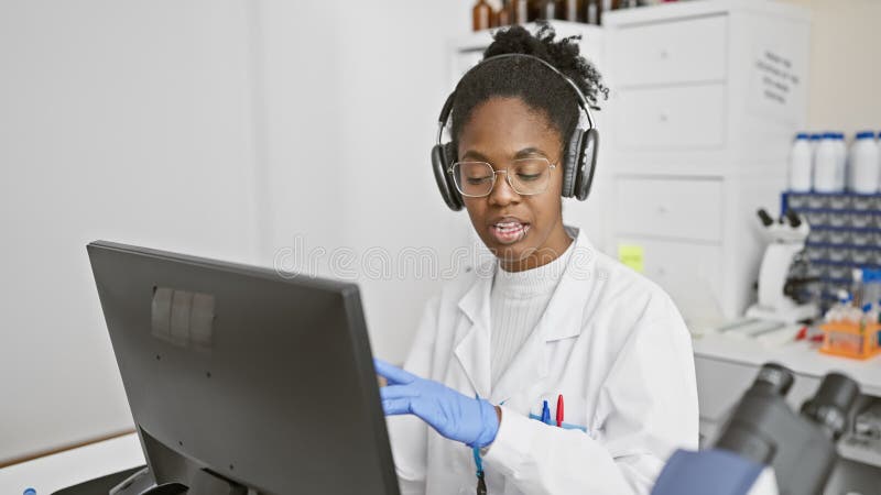 A Focused African Woman Scientist Working at Her Computer in a ...