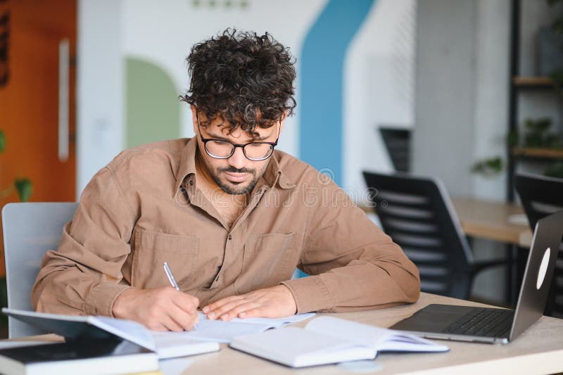 Focused Arab Student Studying and Taking Notes in University Library ...