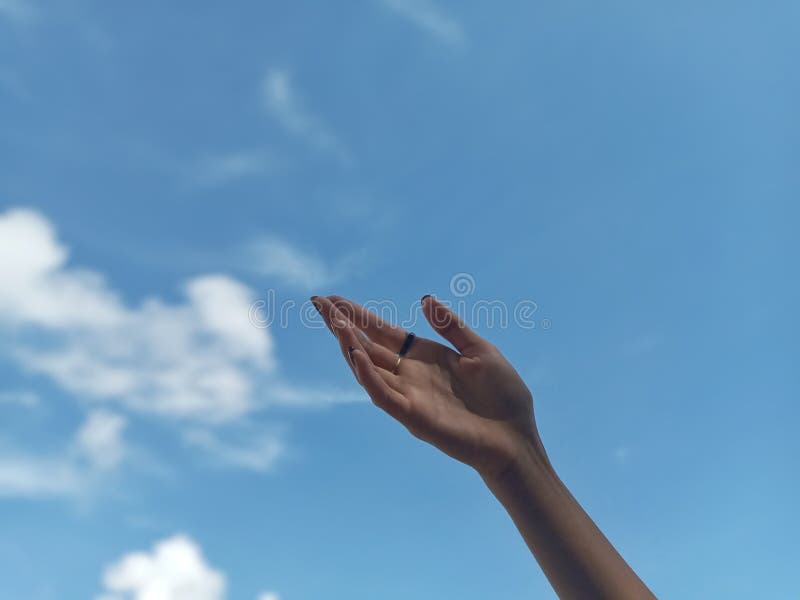 Focused and Artistic Hand with Blurred Blue Sky Background Stock Photo ...