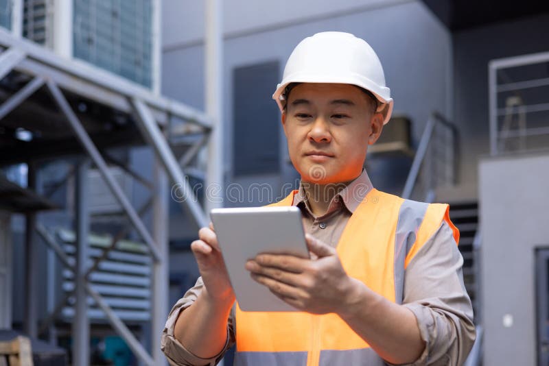 Construction Worker Inspecting Project on Tablet at Site Stock Photo ...