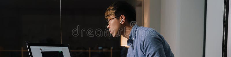 Focused Asian Guy Drinking Coffee while Working with Computers Stock ...