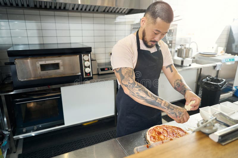 Concentrated Chef Putting Grated Cheese on Top of Pizza Stock Photo ...