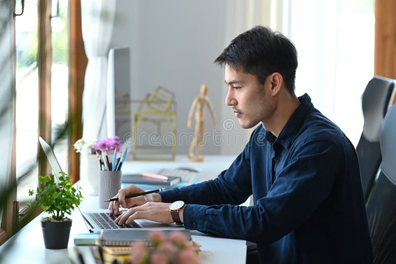 Focused Man Working with Laptop Computer at Bright Modern Office. Stock ...