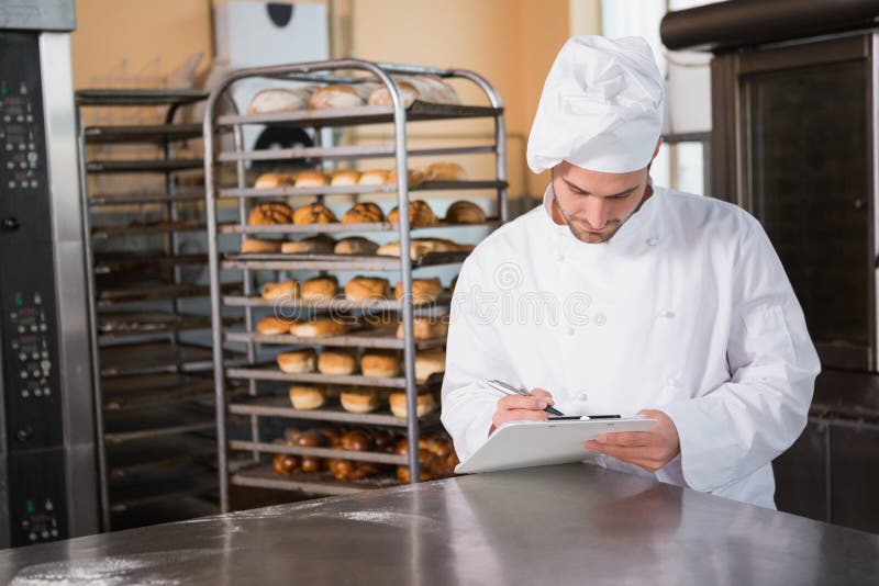 Focused Baker Writing on Clipboard Stock Photo - Image of profession ...