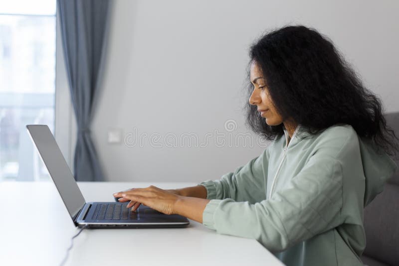 Focused Bipoc Woman Typing Text On Notebook Keyboard Programmer Coding On Laptop Computer At