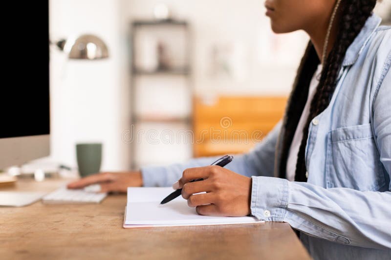 Focused Black Female Student Writing Notes with Computer on Desk for ...