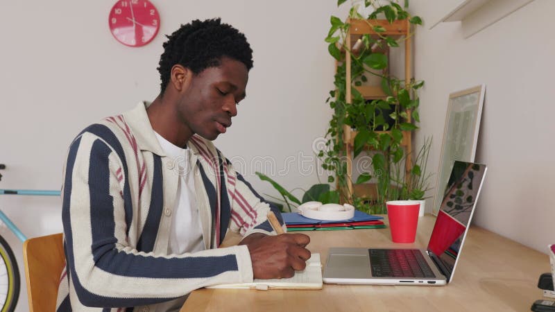 Focused Black Man Taking Notes while Working on Laptop from Home Stock ...