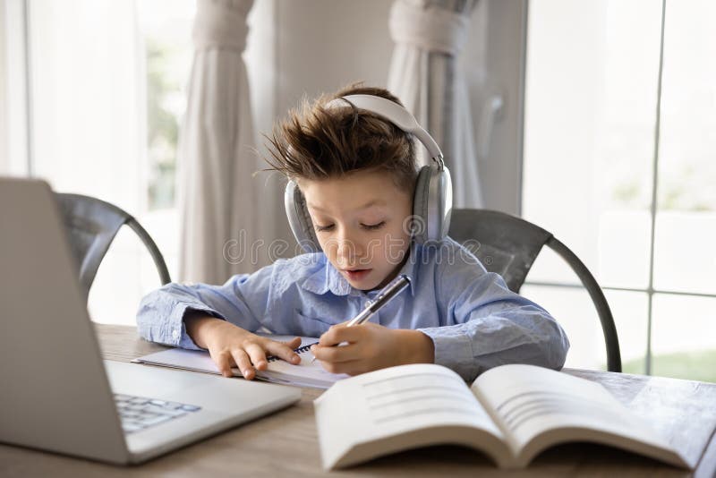 Boy Listens Audio Course, E-learning Seated at Table with Laptop Stock ...