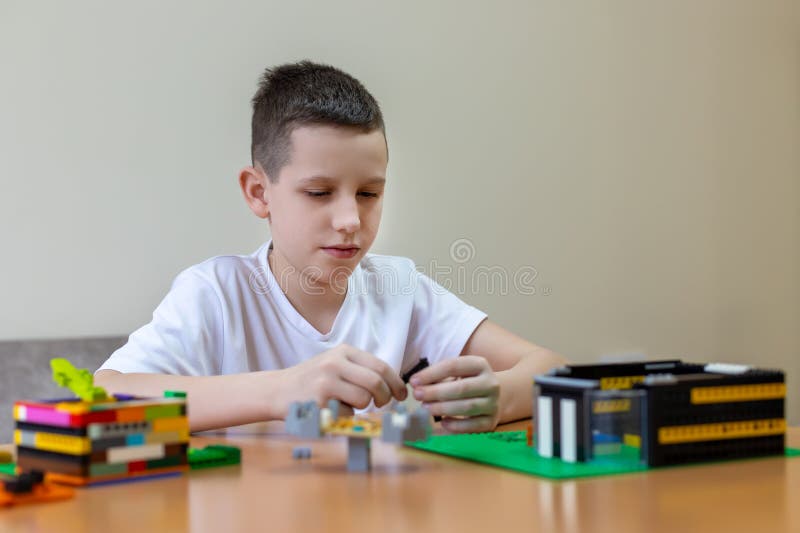Focused Boy in White Shirt Building with Colorful Plastic Bricks ...
