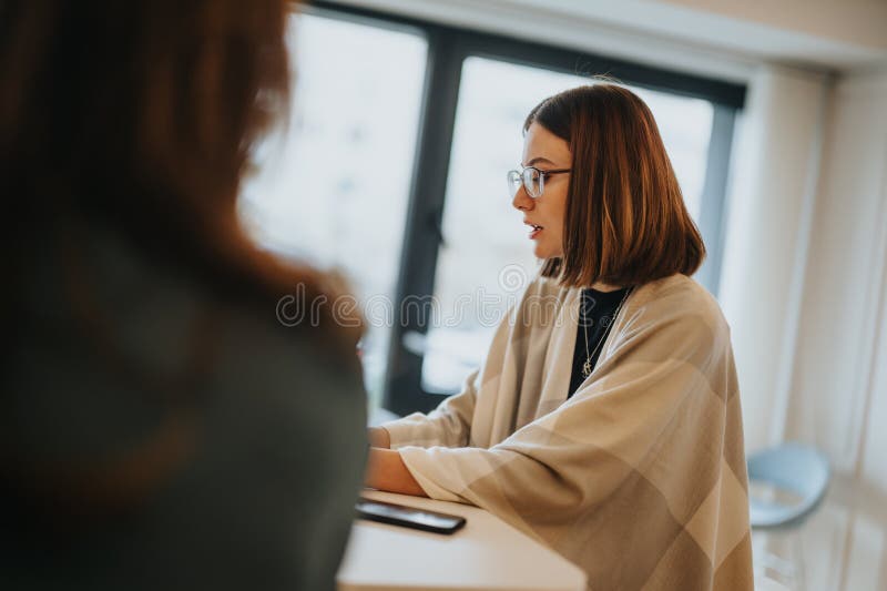 Focused Businesswoman Engaging in Conversation in a Bright Office ...