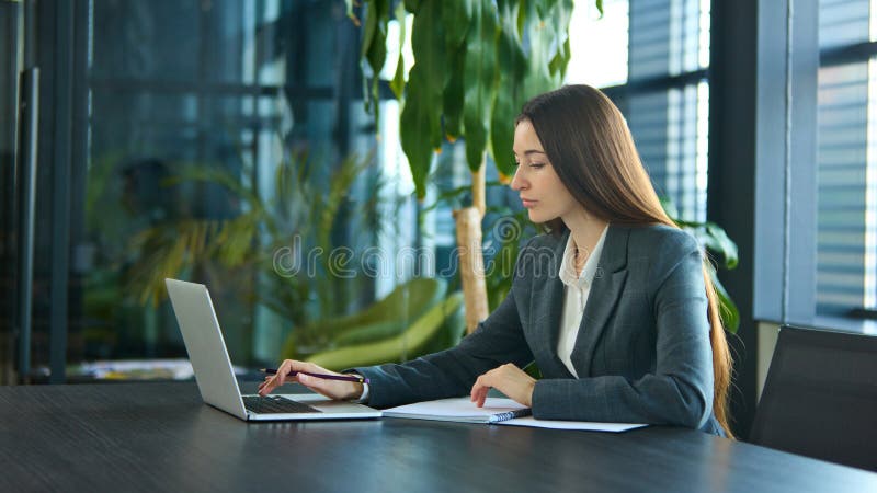 Focused Businesswoman Typing on Laptop, Analyzing Data and Taking Notes ...