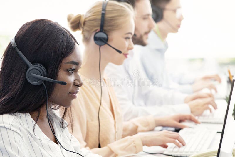 Focused Call Centre Operators with Headphones Working with Computers at ...