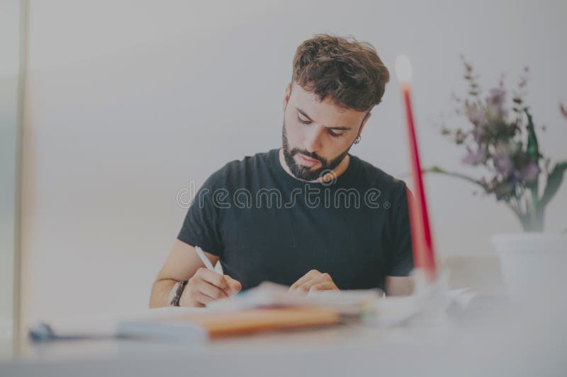 Focused College Student Studying at Home with Candlelight and Flowers ...