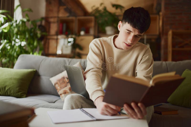 Focused and Concerted Man, Student Sitting on Sofa at Home with Modern ...