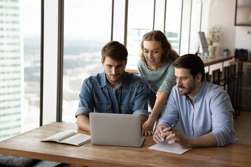 Focused Creative Group Watching Virtual Presentation on Laptop Together ...