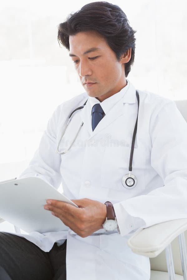Focused Doctor Reading Over Notes Stock Photo - Image of examination ...