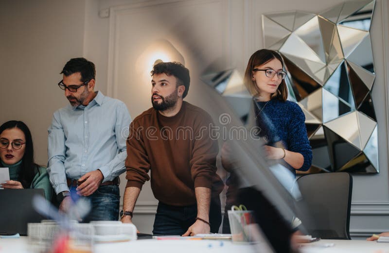 Focused Group of Colleagues Collaborating on a Project in a Well-lit ...