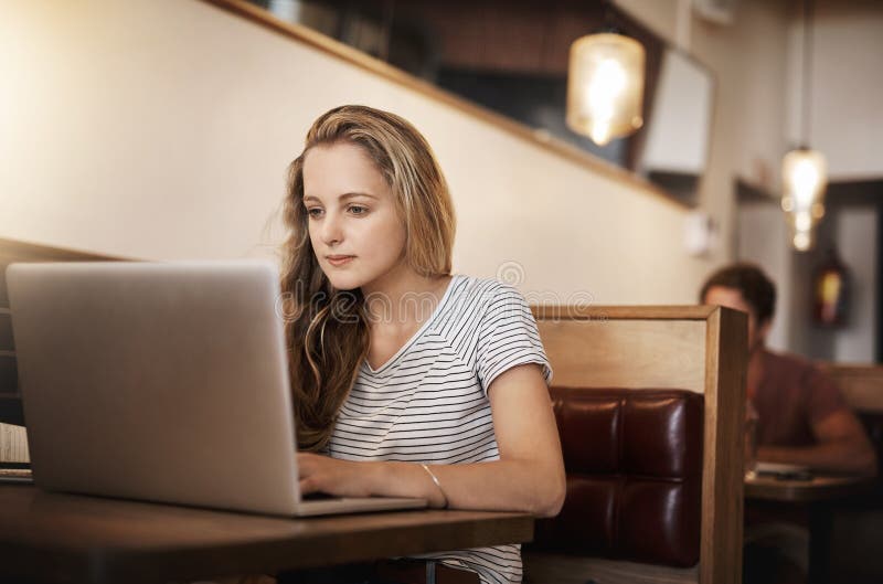 Focused on Her Studies. a Focussed Young Student Using Her Laptop To ...