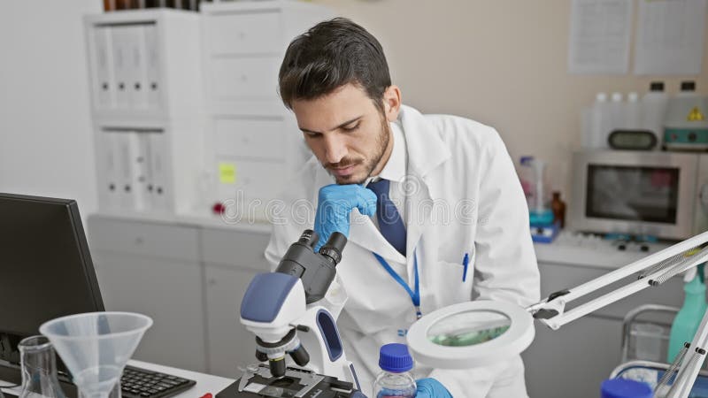 Man in a Lab Coat Using a Microscope To Examine a Sample, Suitable for ...