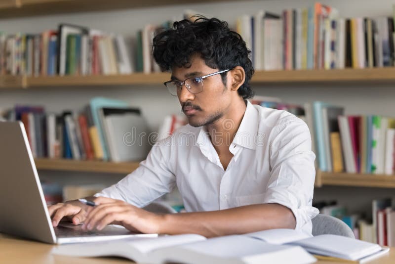 Focused Indian Student Guy Studying Sit at Desk in Library Stock Photo ...
