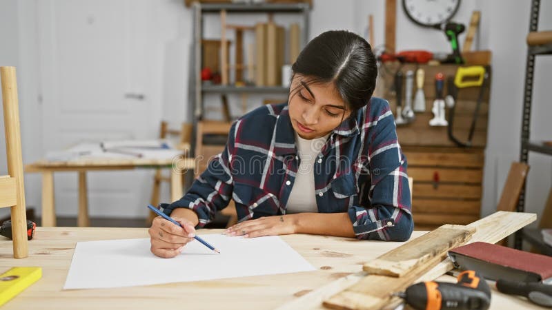 Focused Indian Woman Drawing Plans at a Carpentry Workshop Table ...