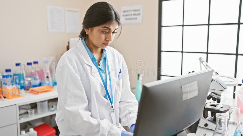 A Focused Indian Woman Scientist Analyzes Data on a Computer in a ...