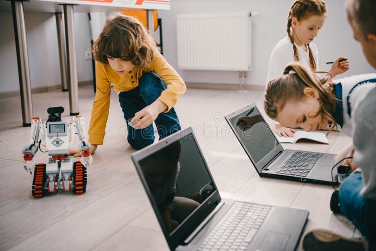 Focused Kids Programming Robots with Computers while Sitting Stock ...