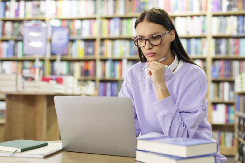 Focused Lady Using Laptop and Studying Online in Library Interior ...