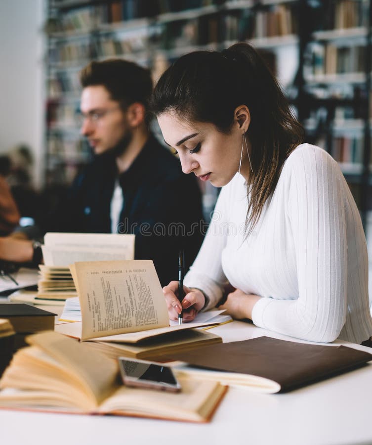 Focused Lady Writing Memo in Notepad in Library Stock Image - Image of ...