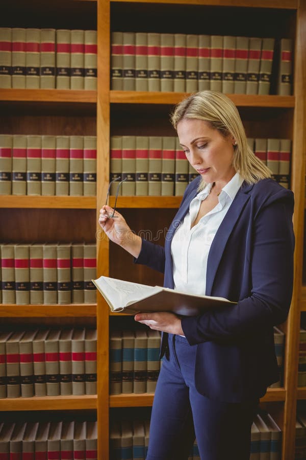 Focused Librarian Reading Book and Holding Reading Glasses Stock Photo ...