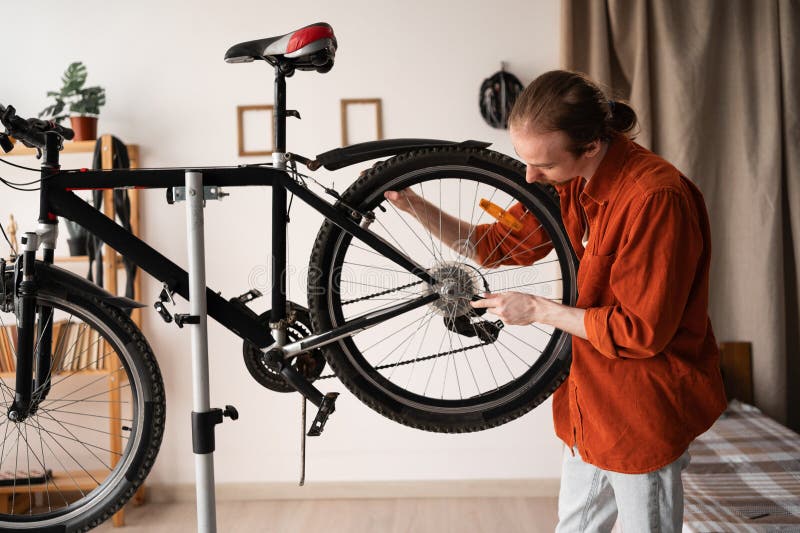 Focused Long Haired Man Fixing Bicycle at Home, Using a Spanner Wrench ...